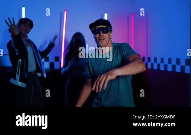 Skilled break dancer dancing in front of camera while diverse friend ...