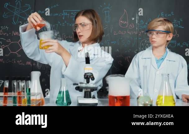 Smart caucasian teacher mixing chemical liquid in science laboratory ...
