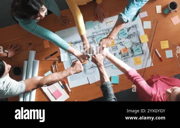 Top down view of business team work together and putting fist together at meeting room. Aerial ...