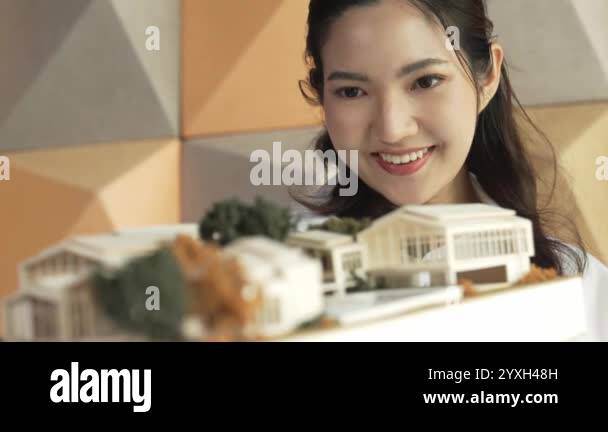 Skilled attractive architect engineer holds architect model while ... Skilled attractive architect engineer holds architect model while ...
