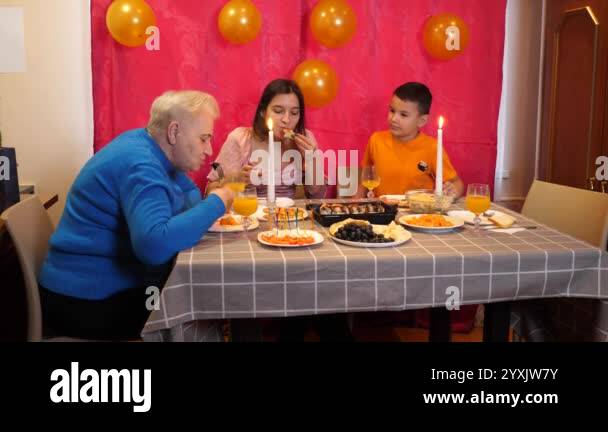 Celebrating a girl's birthday, people sit down at the table, drink ...