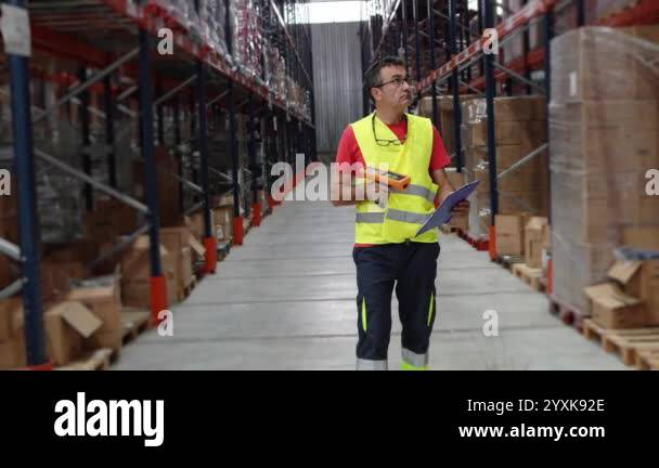 Warehouse worker using a scanner to check inventory in a spacious ...