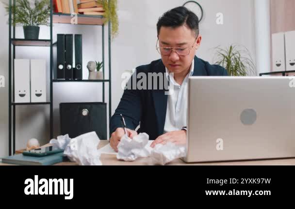 Angry furious Asian businessman working at office throwing crumpled ...