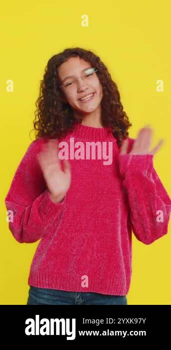 Young Caucasian girl smiling friendly at camera, waving hands gesturing ...
