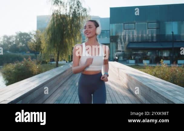 Active sportswoman jogging training marathon run, listening to music in ...