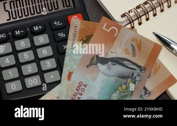New Zealand dollars and calculator. Counting money and putting it on ...
