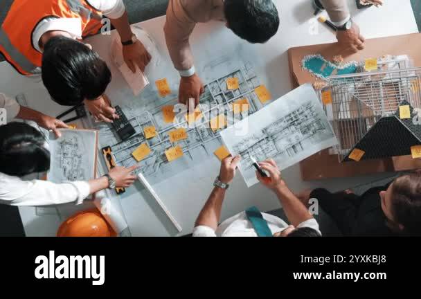 Top down view of skilled engineer team compare between blueprint and house plan. Aerial view of ...