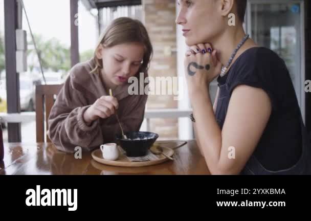 A joyful moment between a mother and her daughter sharing ice cream at ...