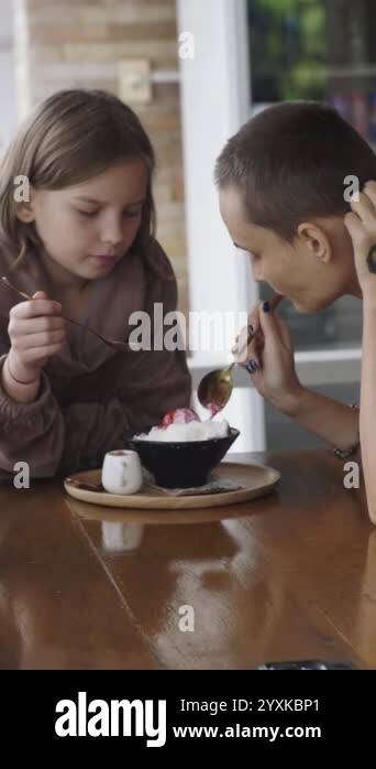 A joyful moment between a mother and her daughter sharing ice cream at ...