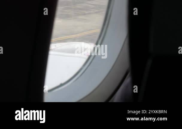 view through airplane aircraft window with jet engine and wing while ...