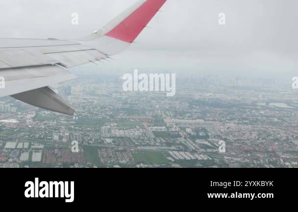 landscape view through plane window with wingview while flying into ...