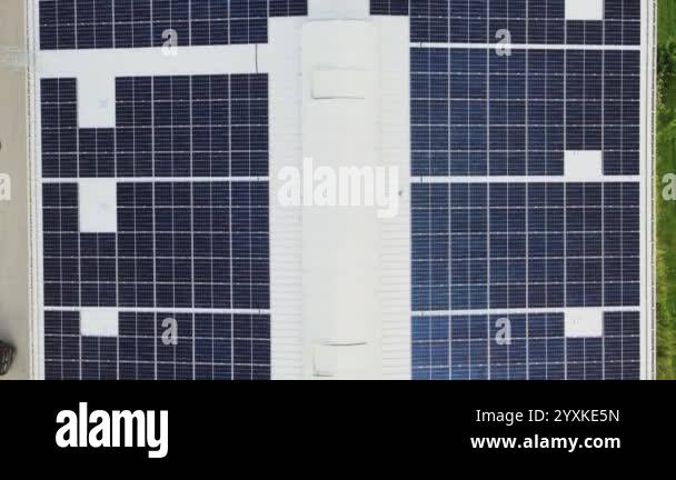 Drone Aerial View of Numerous Solar Panels on the Metal Roof of a Large Industrial Facility ...