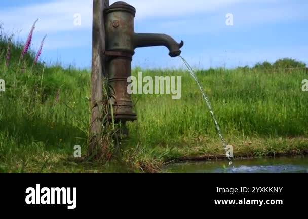 Rusty water fountain is spraying water into the air. The water is clear ...