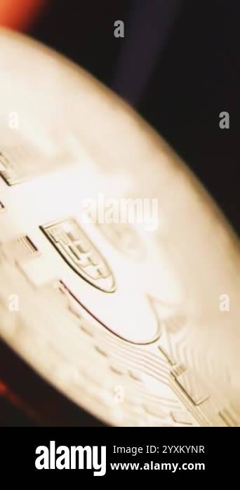 Vertical shot of gold bitcoin coin spinning on the black background ...
