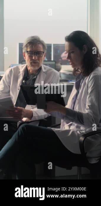 Two diverse scientists in lab coats discuss scientific research, look ...