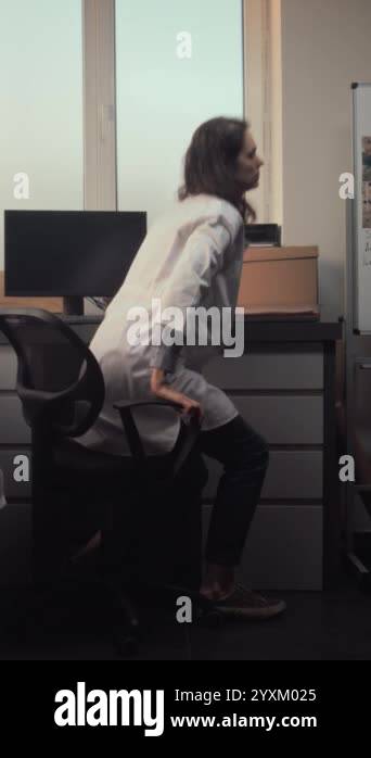 Female scientist takes off lab coat, turns off personal computer and ...
