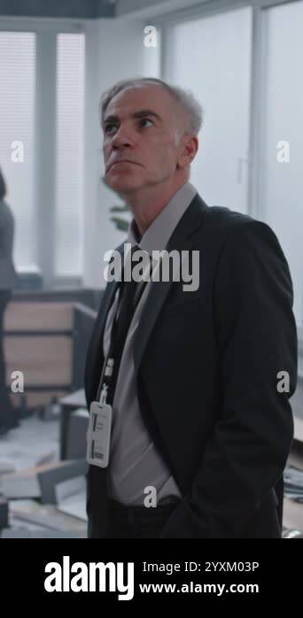 Office robbery case: Vertical shot of male detective examining crime ...