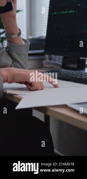 Vertical shot of female financier working with paper documents and ...