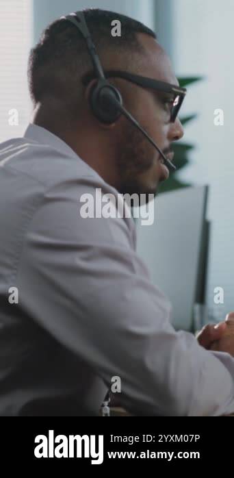 Modern call center office: Vertical shot of African American technical customer support ...