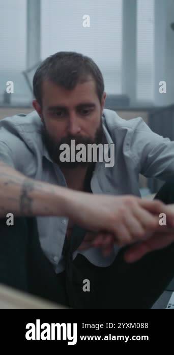 Frustrated office worker sits on the floor in destroyed office room ...
