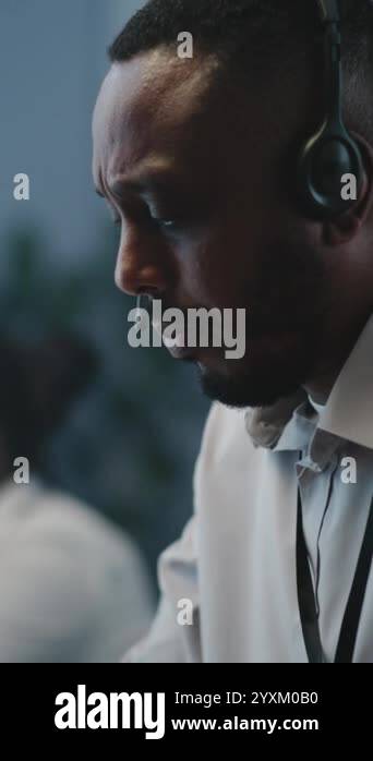 Call center office of psychological helpline: Vertical shot of African ...