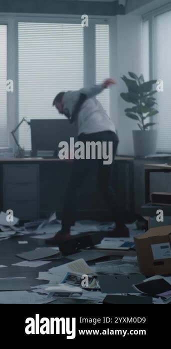 Vertical shot of aggressive businessman throwing folders and papers off ...