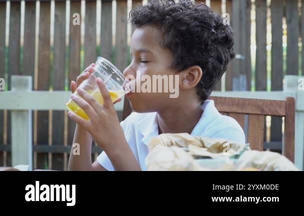 African American teenager drinks lemonade in the park outdoors, curly ...