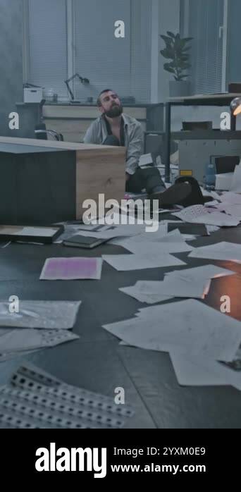 Vertical shot of depressed office worker sitting on the floor in ...