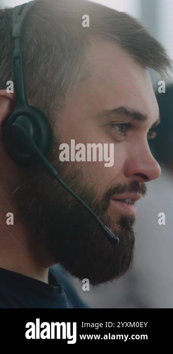 Modern call center office: Vertical shot of Caucasian technical support specialist in headset ...