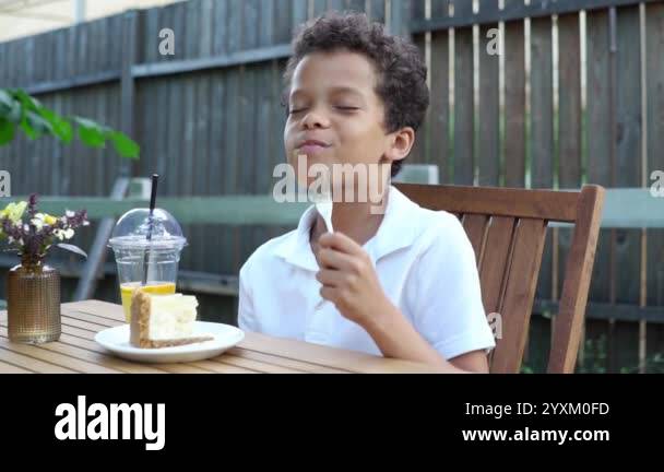 hungry african american teenager eating cheesecake with fork in park ...