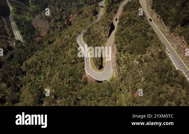 Aerial drone shot over Madeira summits and peaks. Winding roads in ...
