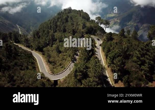 Aerial drone shot over Madeira summits and peaks. Winding roads in ...