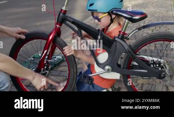 Preschooler boy learns to fix bicycle with help of father. Child ...