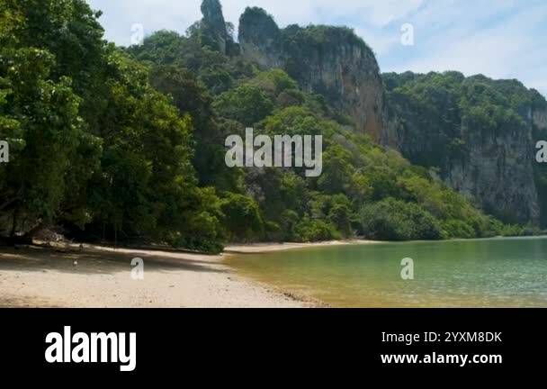 Railay sandy beach with turquoise water, lush greenery and limestone ...