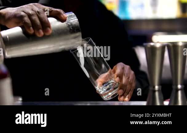 Professional man bartender shaking cocktail drink in cocktail shaker ...