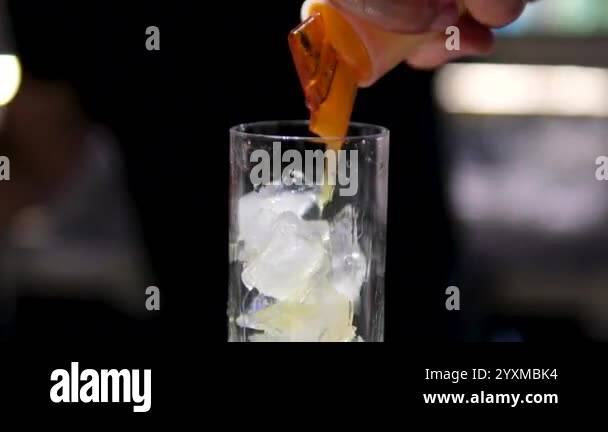Making fresh summer cocktail. pouring carbonated water in glass with ice cubes. Slow motion ...