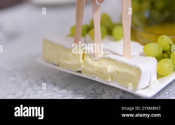 Variety of sliced cheeses with fruits slowly rotating in the frame ...