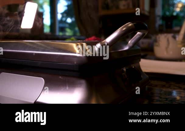 Woman in a white shirt prepares waffles in her kitchen. Opening the ...