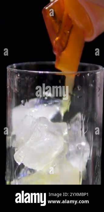 Making fresh summer cocktail. pouring carbonated water in glass with ice cubes. Slow motion ...