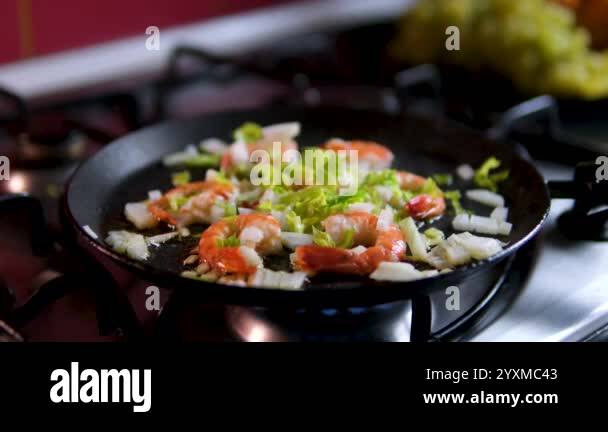 Chef lifting the frying pan lid reveals a mouthwatering dish of prawns ...