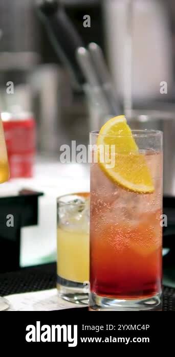 close-up in a professional kitchen, pours alcohol into a cocktail from ...