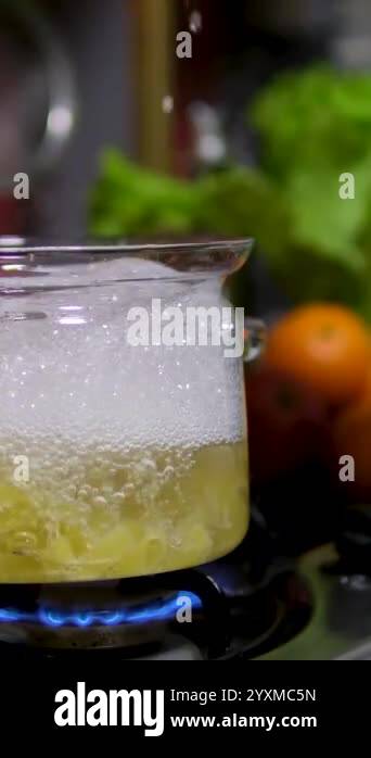 Water boiling in a pot over stove with pasta. Close up of boiling ...