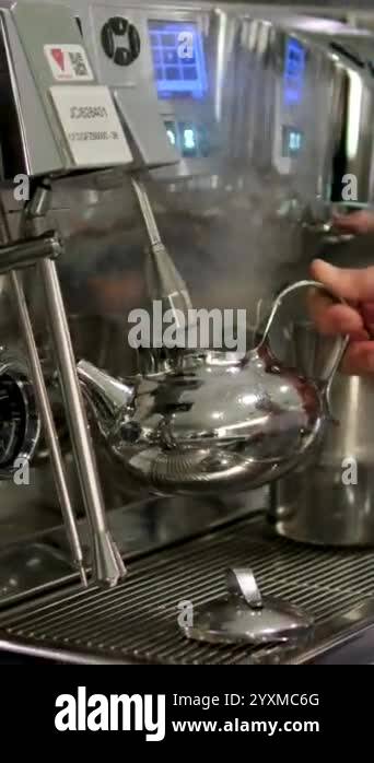 Close-up of young female Caucasian barista adjusting professional ...