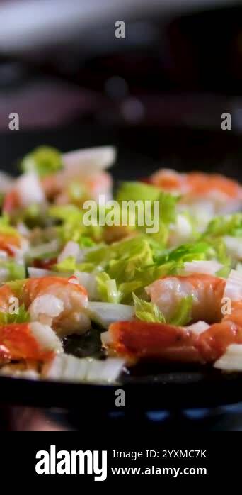 Chef lifting the frying pan lid reveals a mouthwatering dish of prawns ...