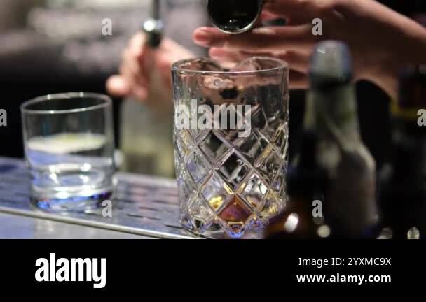 Close up of professional bartender mixing an alcoholic cocktail with ...
