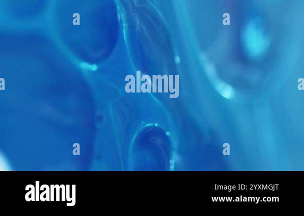 Vertical video. Oil bubbles. Fizzy liquid. Defocused blue white color ...