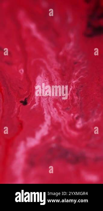 Vertical video. Paint flow. Acrylic liquid spill. Defocused red white ...