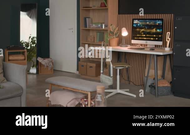 Long handheld shot of stylish home office interior with desk, ergonomic ...