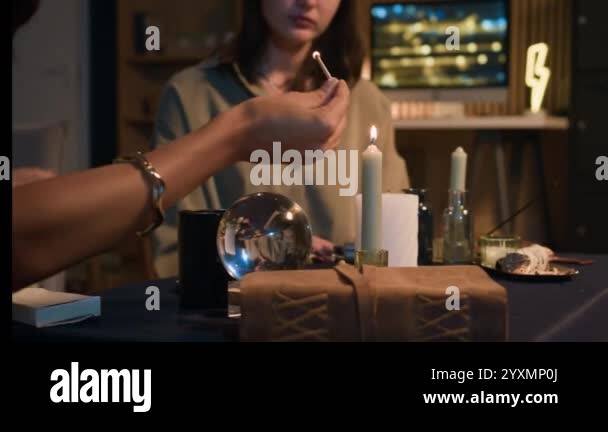 Handheld shot of group of young girls lighting candles while arranging ...