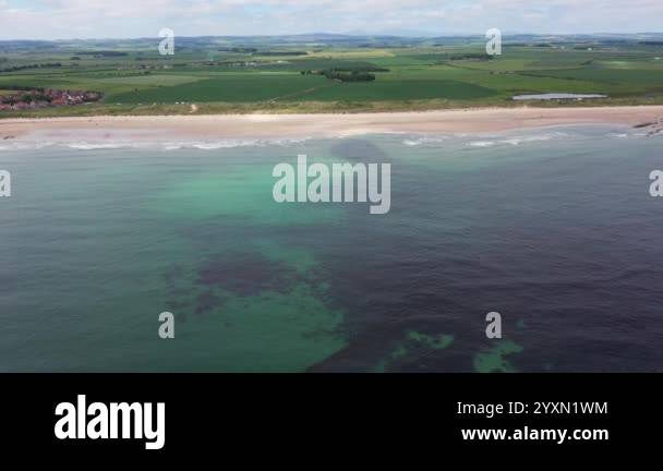 Aerial footage of the seaside coastal town of the village of Seahouses ...